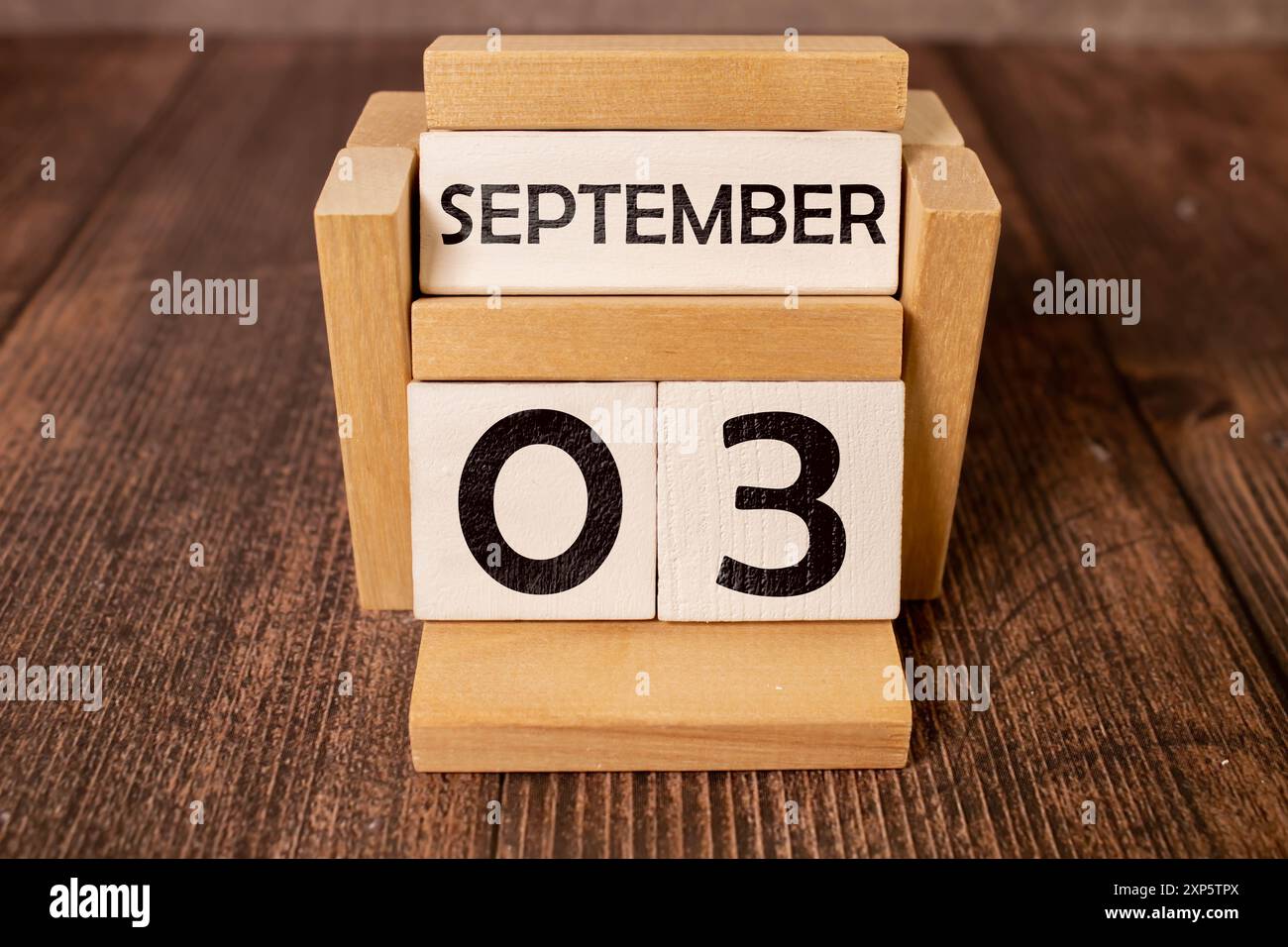 Wooden calendar with the date September 03 and gypsophila flowers on a ...