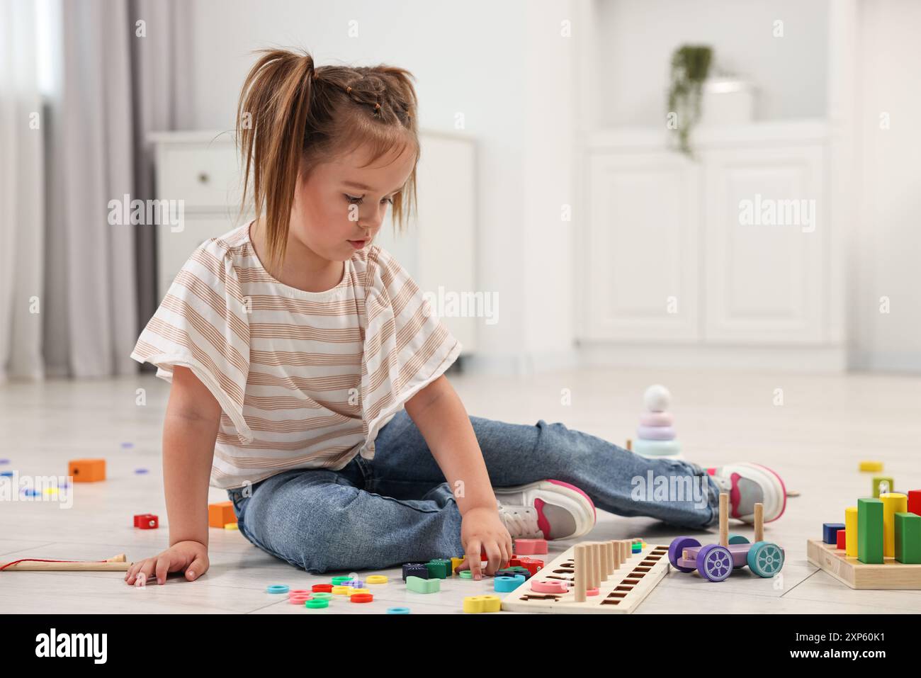 Cute little girl playing with math game Fishing for Numbers on floor ...