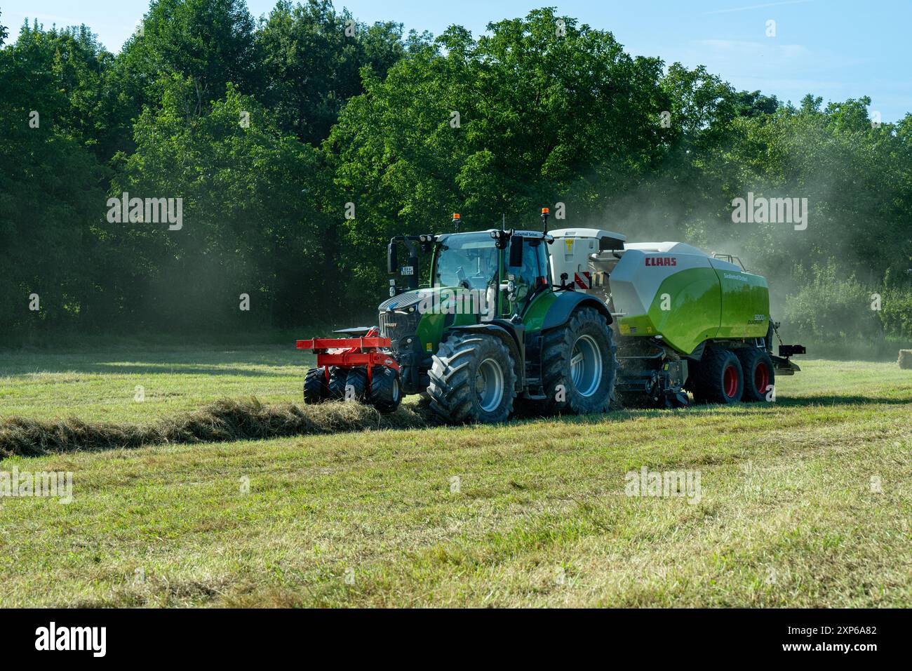 Hay baling, tractor collecting and making hay on a farm Stock Photo - Alamy