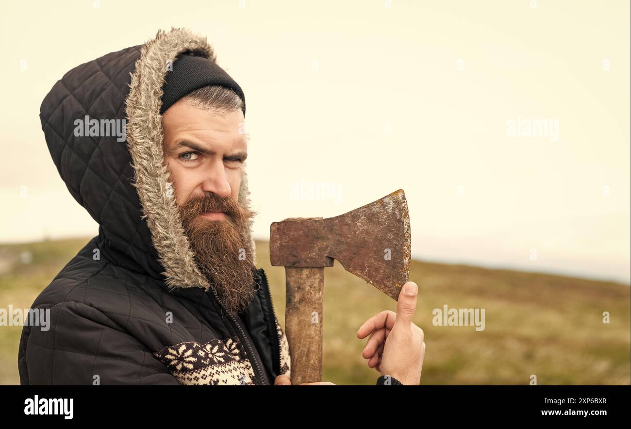 photo of bearded man lumberjack holding axe in the mountain, banner ...