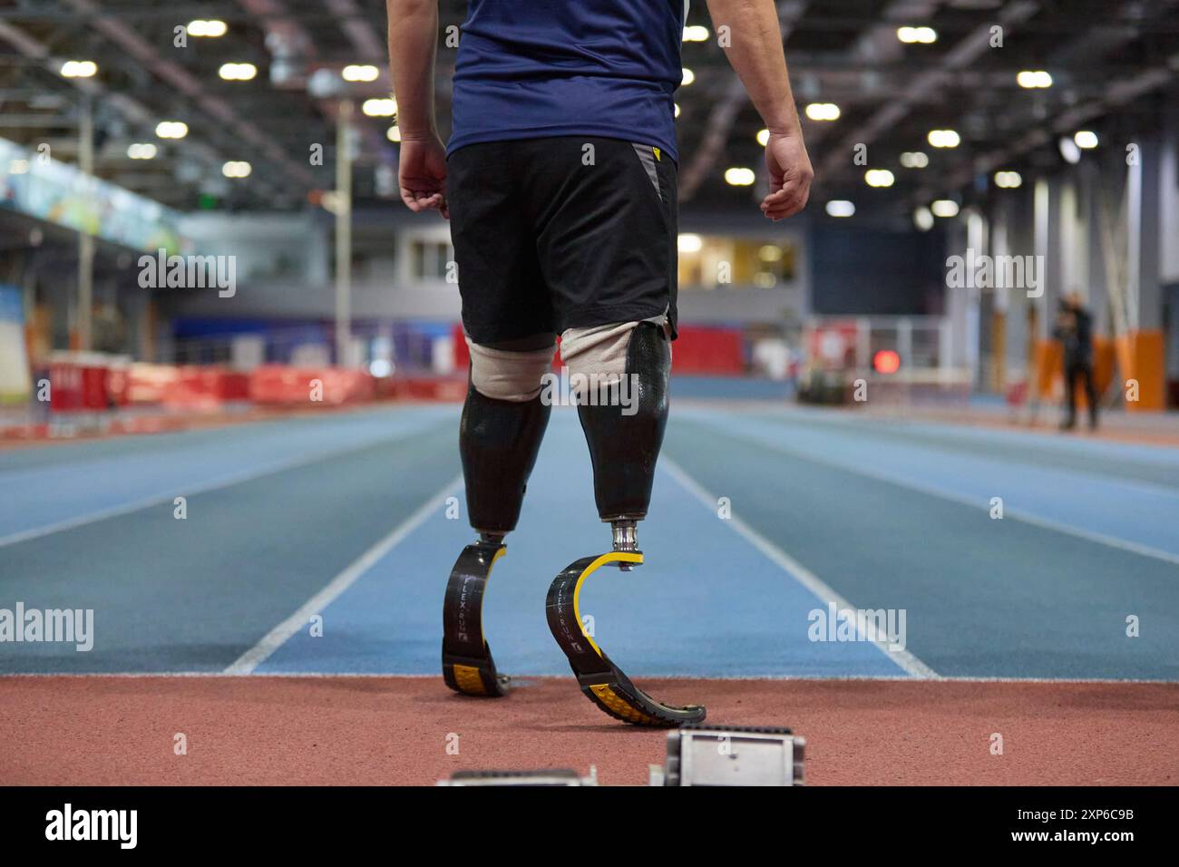 Athlete with amputated legs on a running track. Feet of a wounded ...