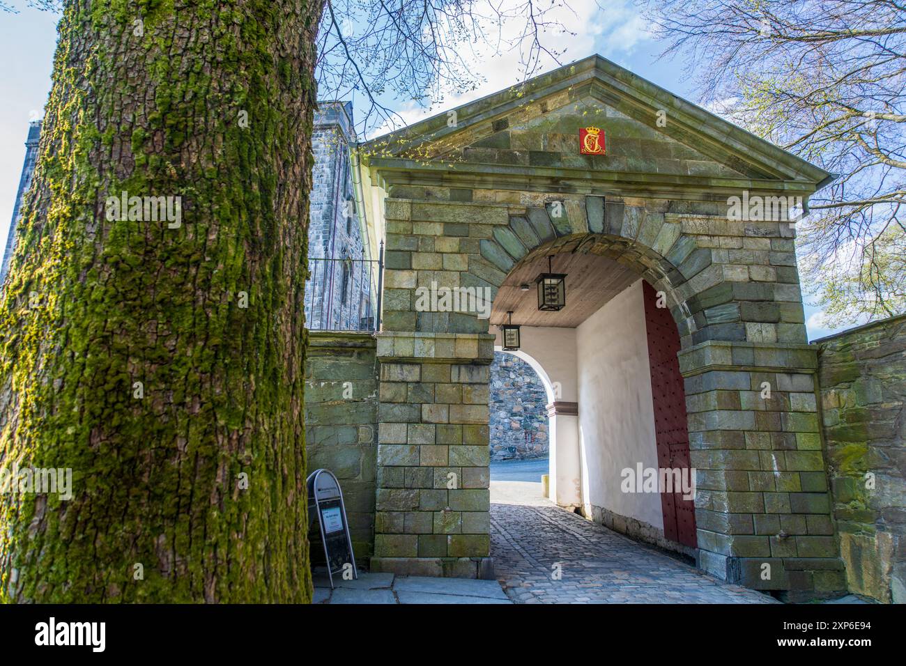 A stone pathway leads through a grand, arched gate towards the historic ...