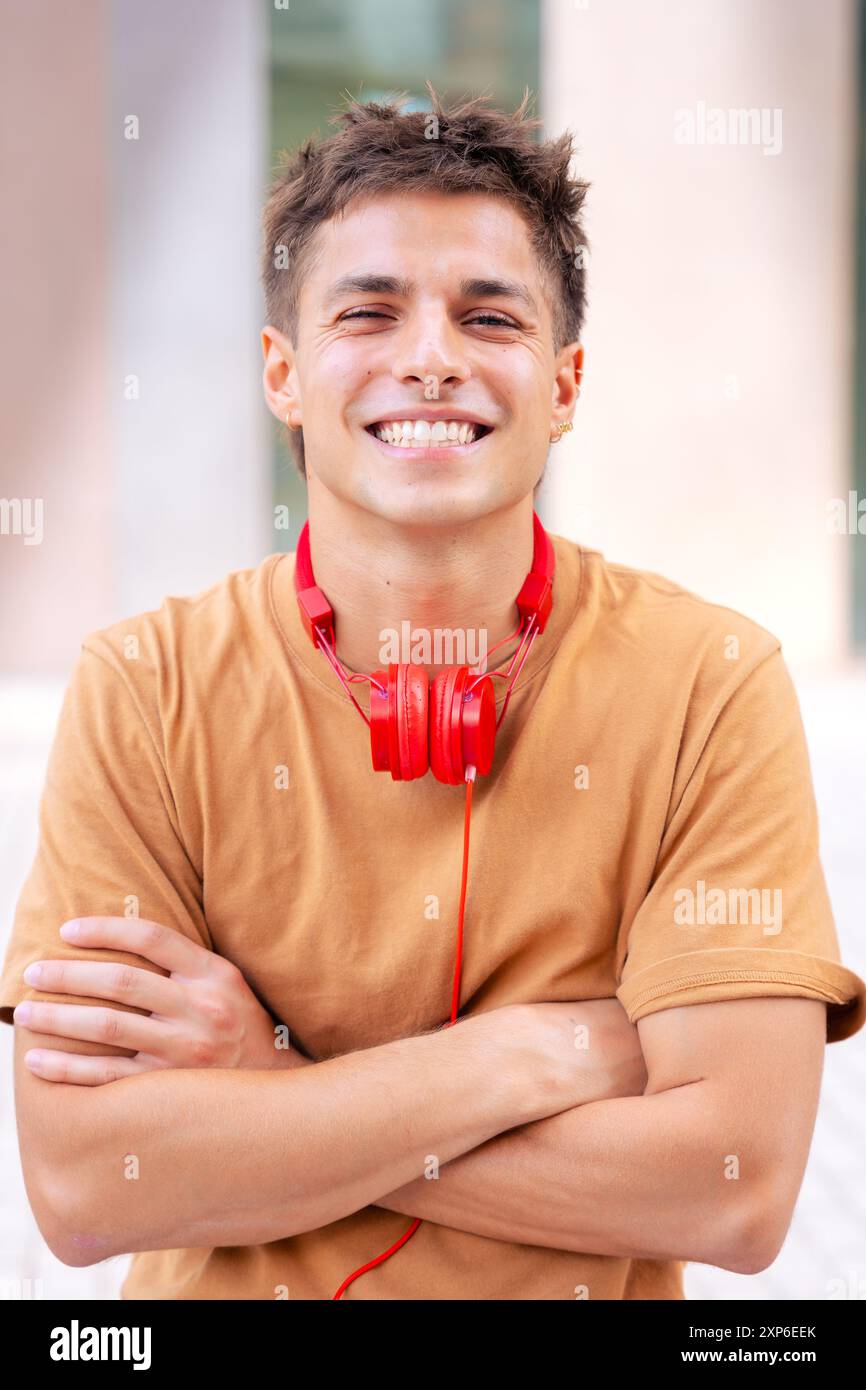 Vertical single portrait young man smiling with arms crossed looking at ...