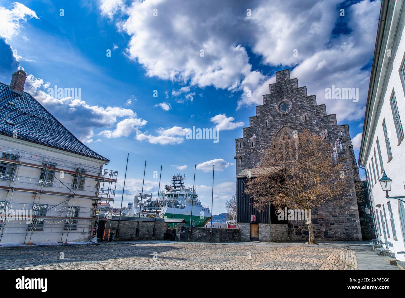A stone pathway leads through a grand, arched gate towards the historic ...