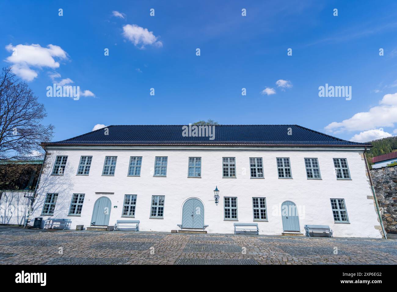 A stone pathway leads through a grand, arched gate towards the historic ...