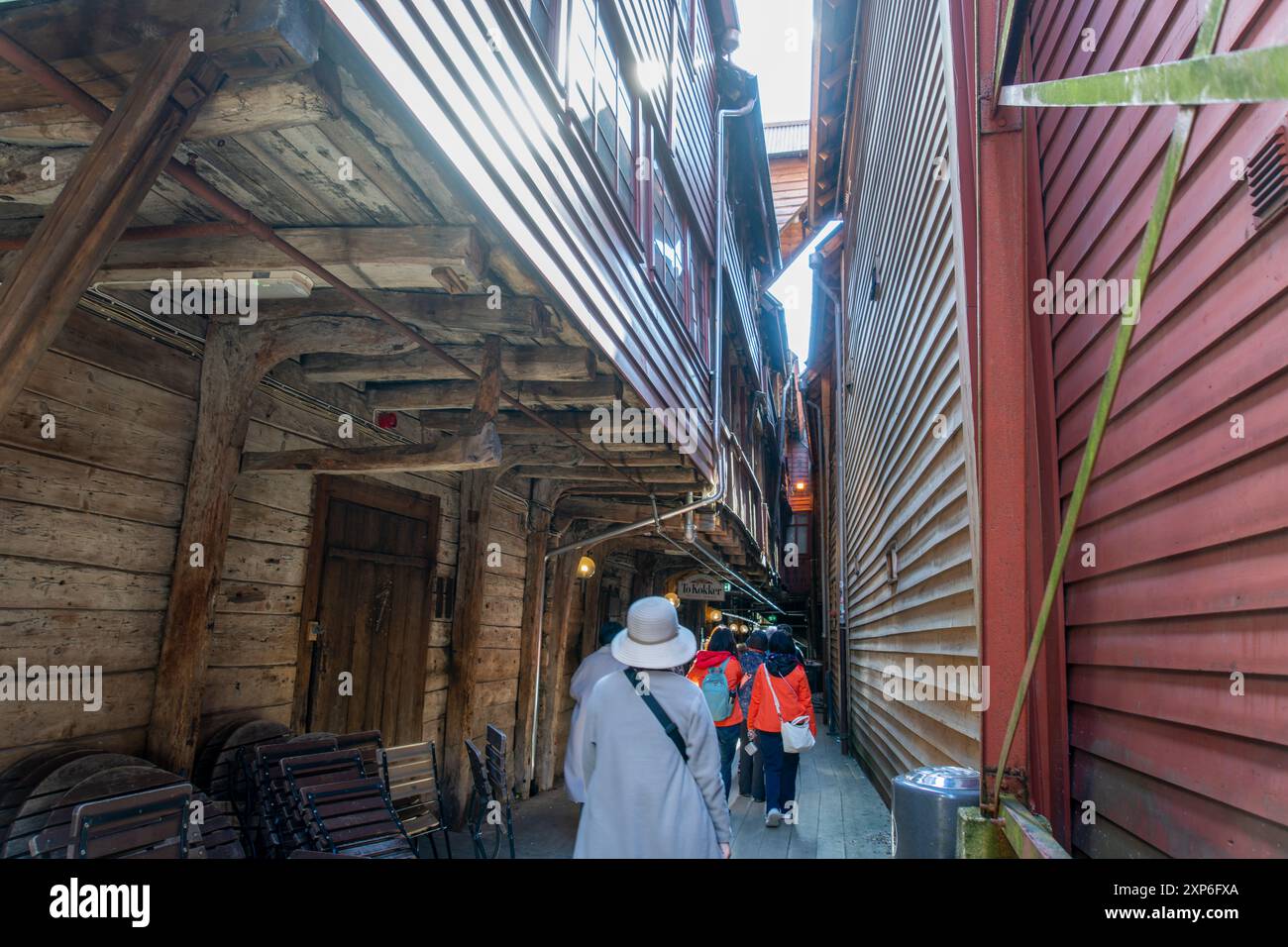 Bergen, Norway - April 30, 2024: Tourists visit a narrow alley lined ...