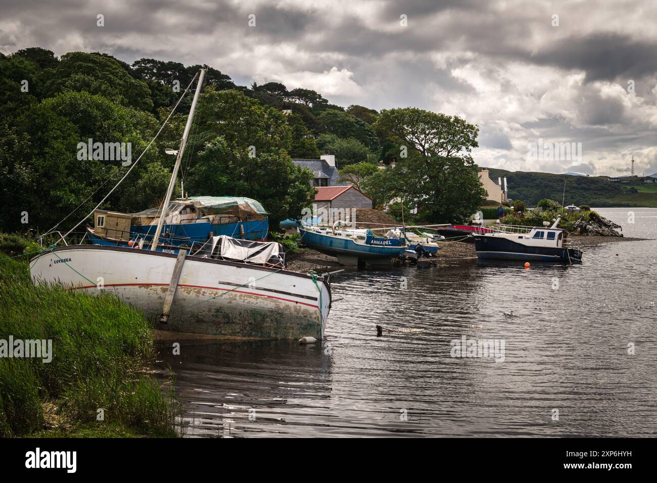 A gloomy summer HDR image of a small boatyard, with eight boats, in ...