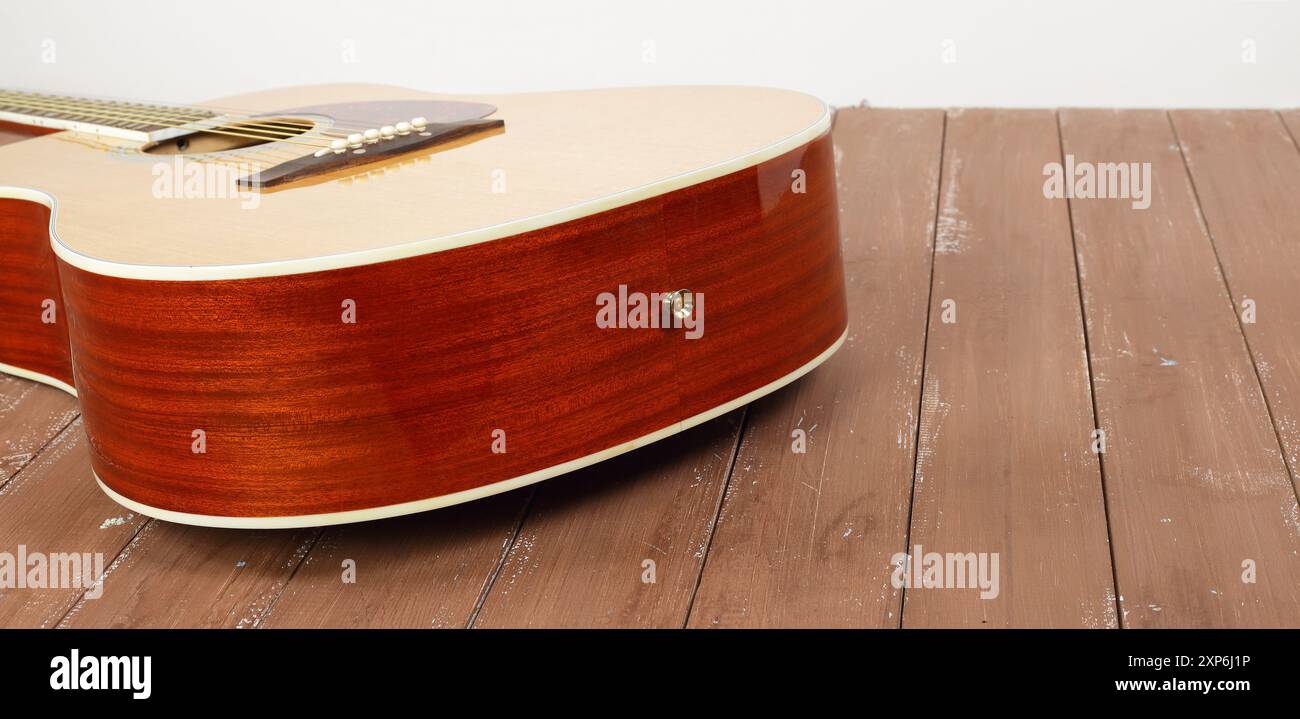 Musical instrument - back view classic acoustic guitar on a white wall ...
