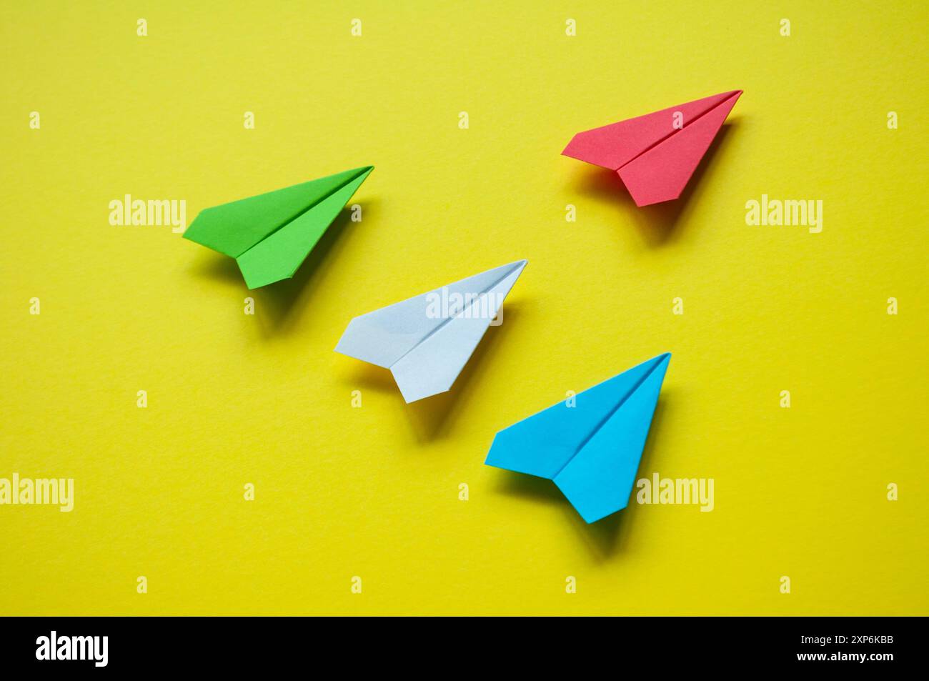 Top view of multicolored paper airplane on yellow background ...