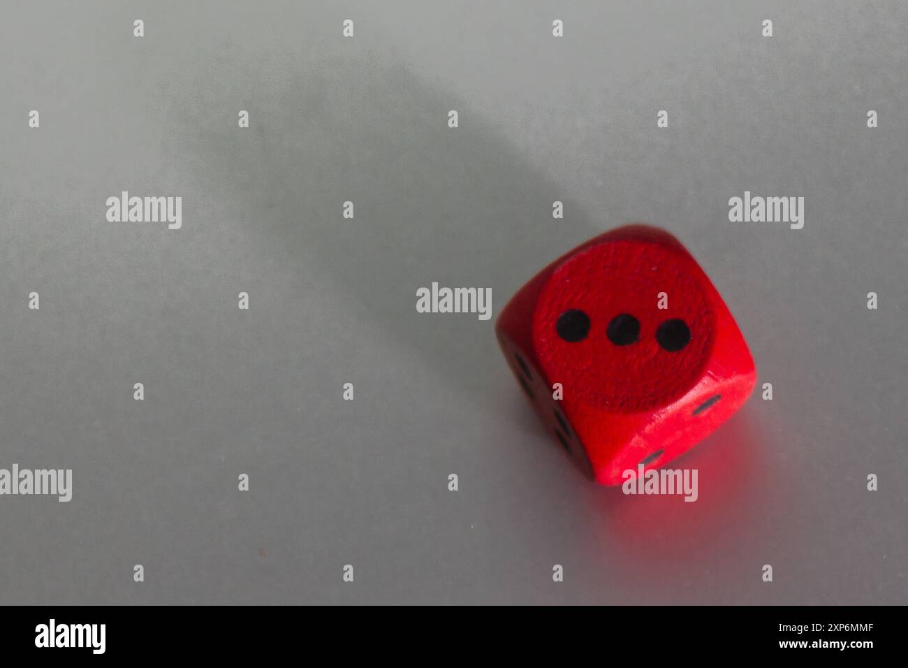 a red dice on a plain background showing the number three Stock Photo ...