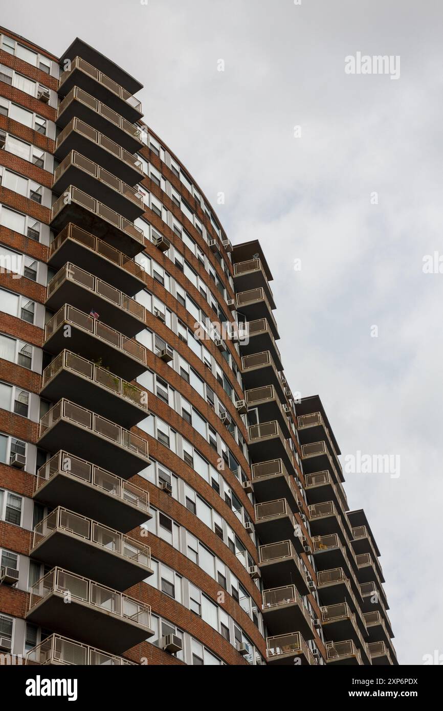 Red brick apartment building facade with rows of balconies in New York ...