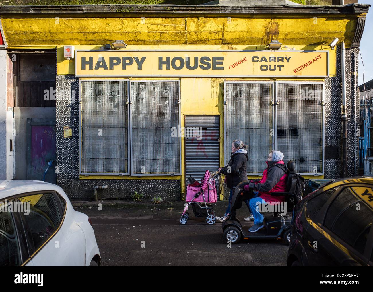 Locals walk past boarded up Happy House Chinese restaurant and Carry ...