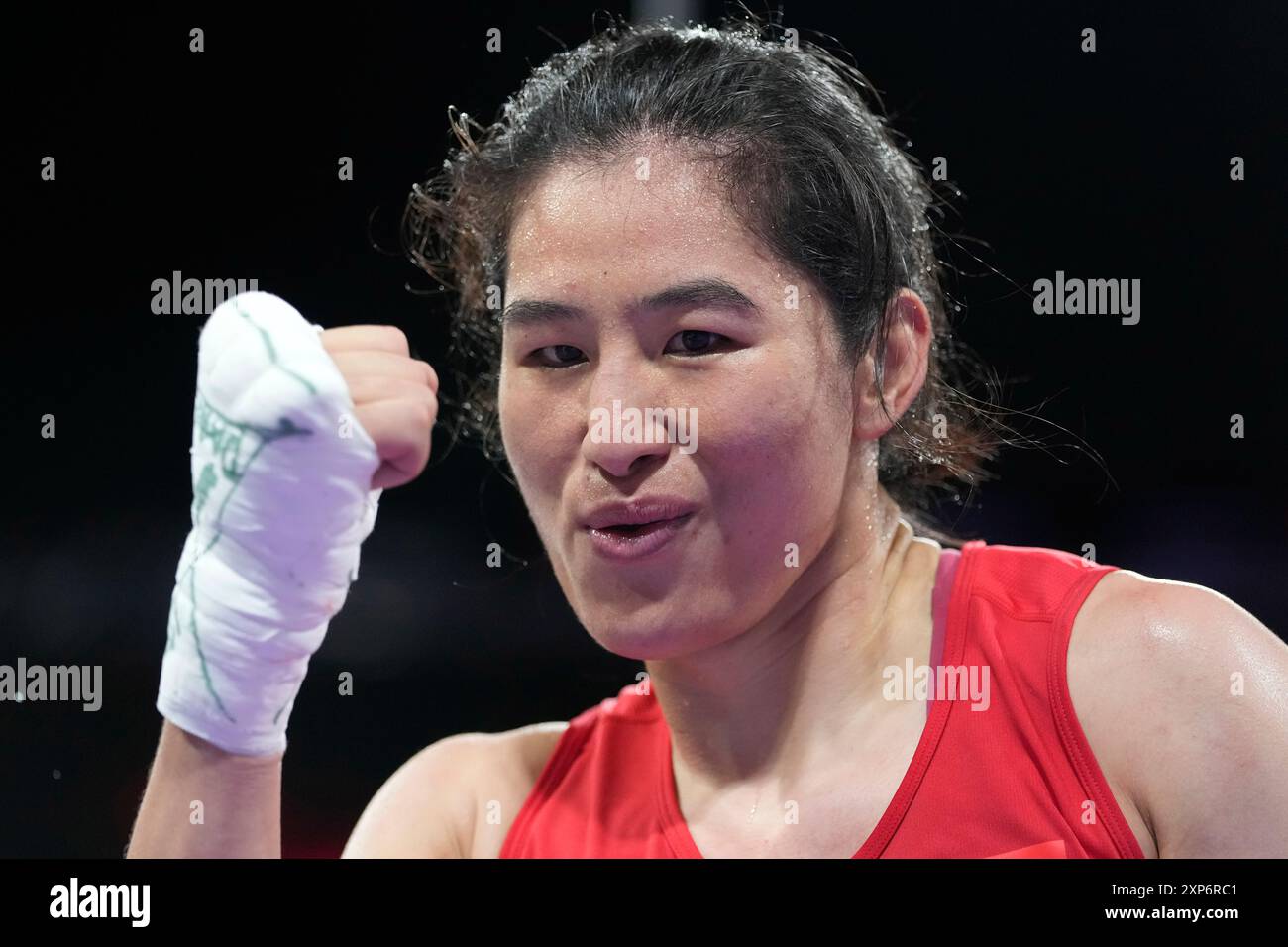 China's Li Qian poses for photographers after defeating India's Lovlina Borgohain in their women ...