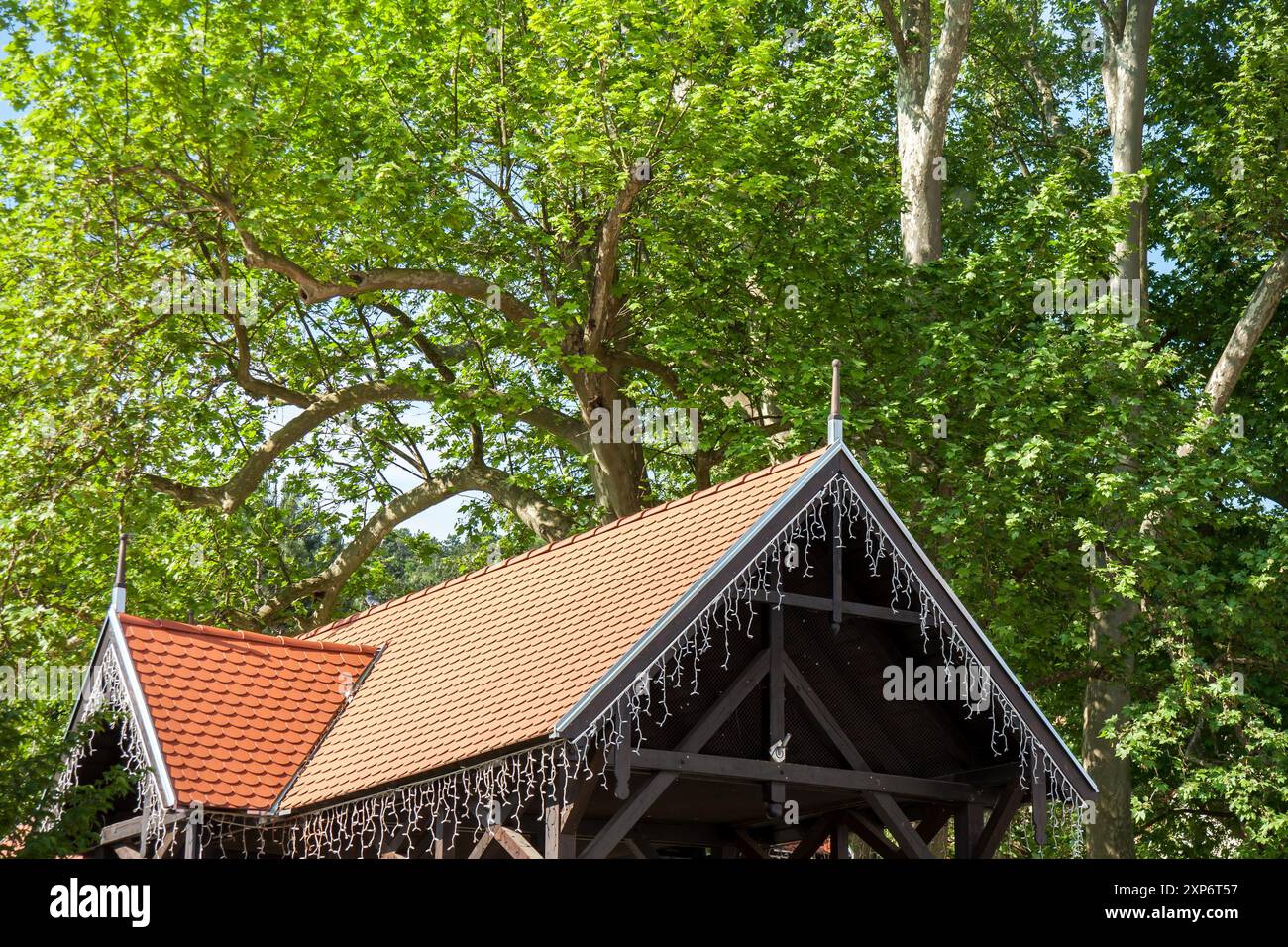 Rustic wooden structure with a terracotta-tiled roof, adorned with ...