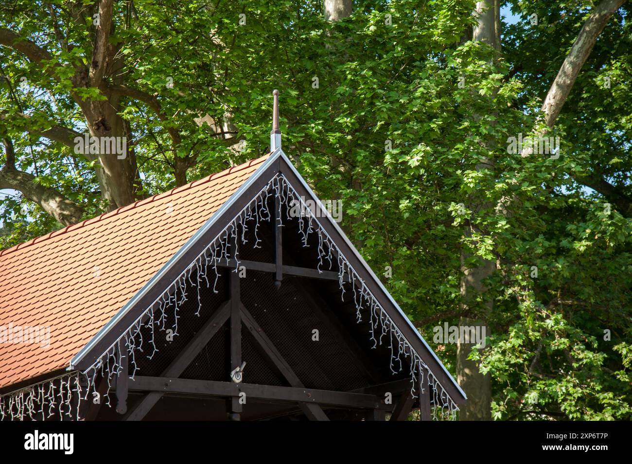 Rustic wooden structure with a terracotta-tiled roof, adorned with ...