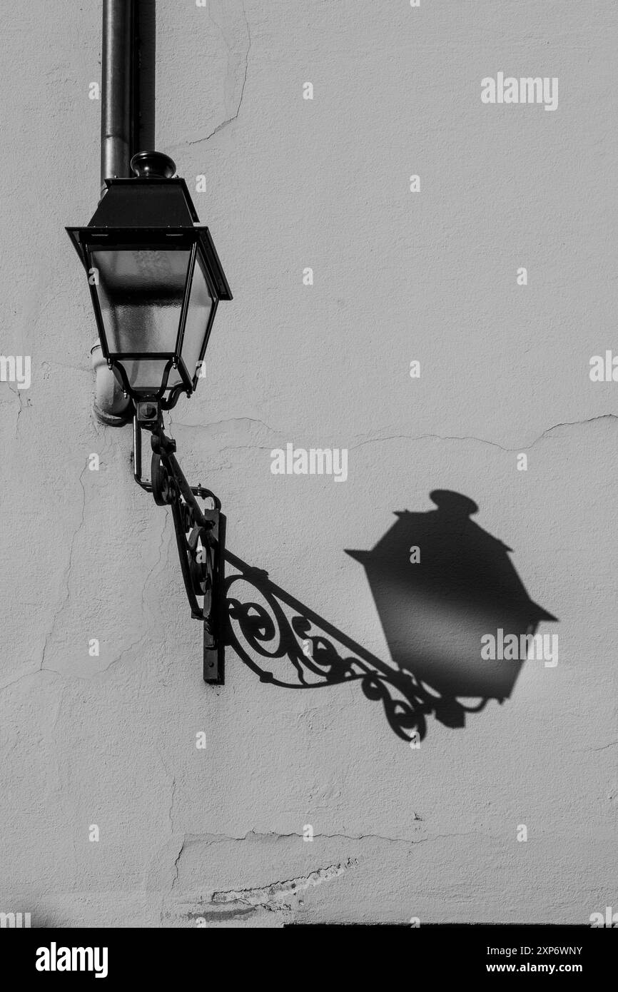 Wrought-iron lantern with its shadow on a street wall, Colmar, Alsace ...