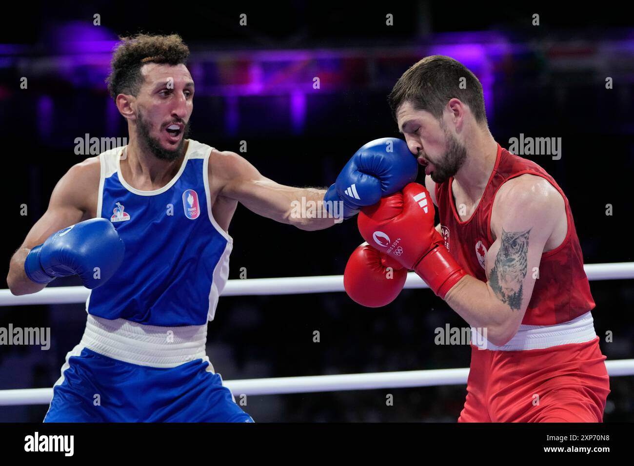 France's Sofiane Oumiha hits Canada's Wyatt Sanford in their men's 63.5 ...