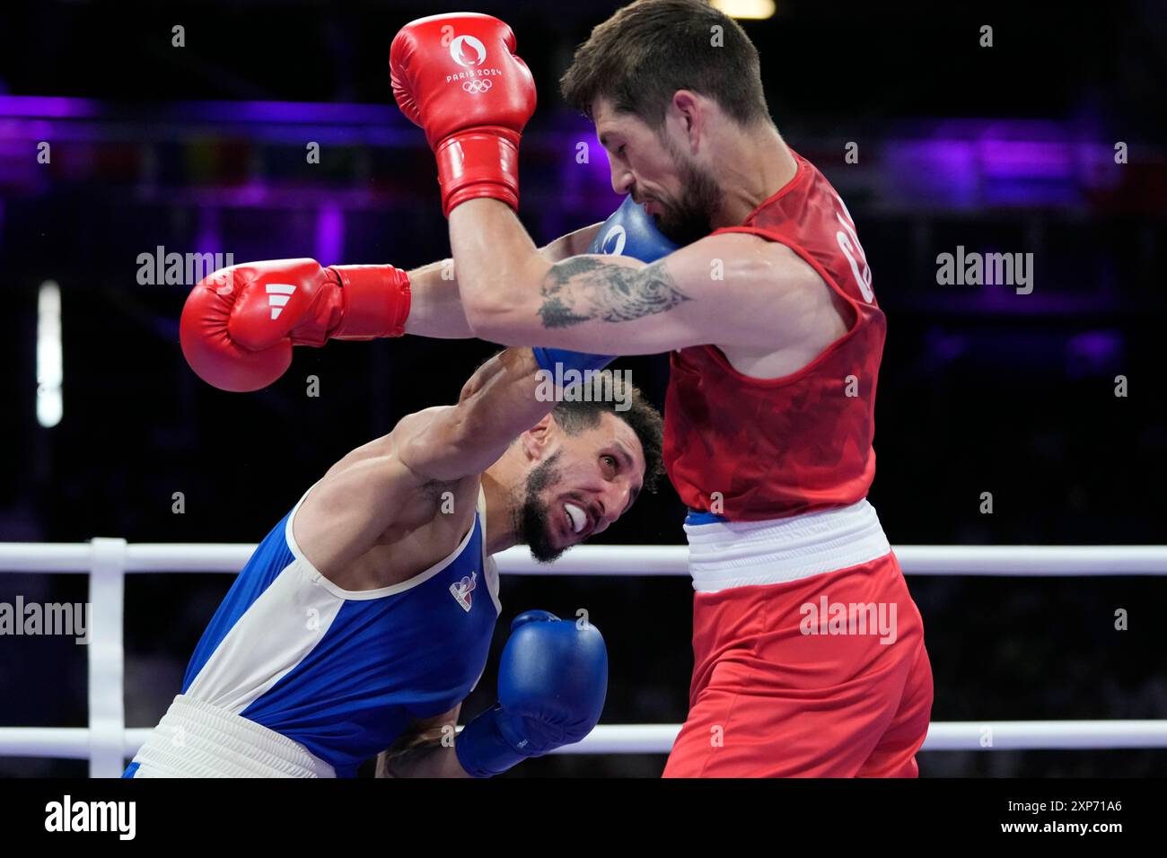 France's Sofiane Oumiha, left, hits Canada's Wyatt Sanford in their men ...