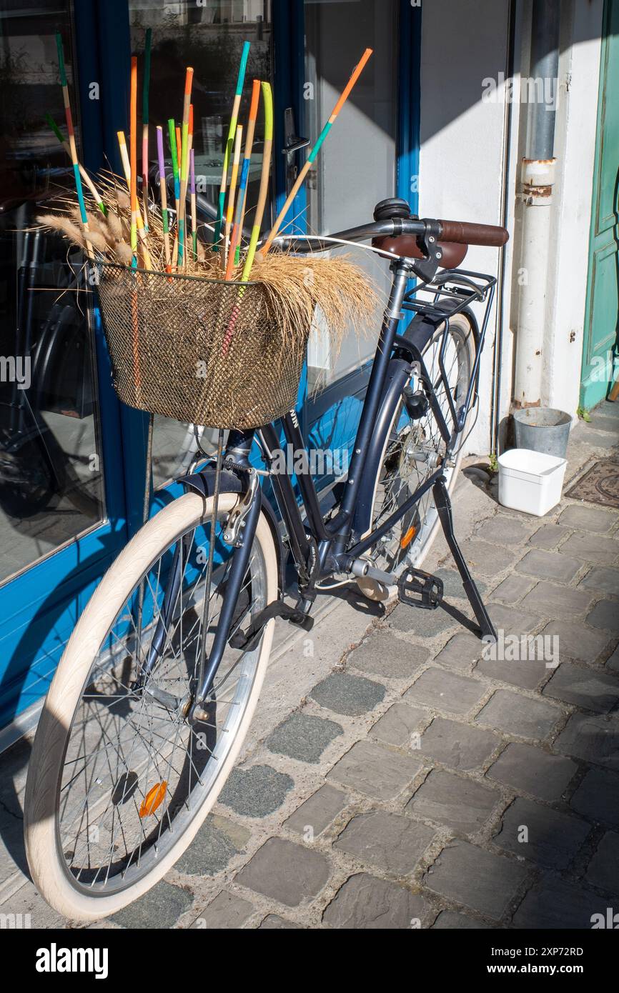 French bicycle with decorative flower basket outside a French cafe in ...