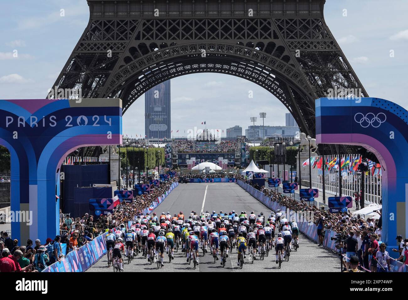 Cyclists ride by the Eiffel Tower as they start the women's road ...