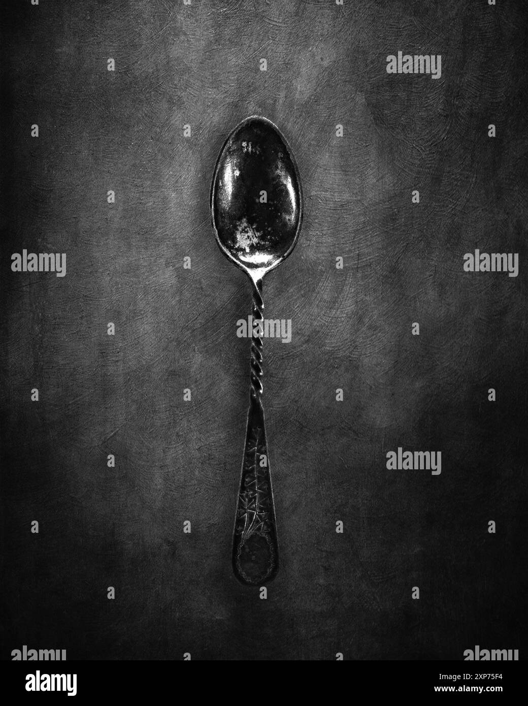 Tarnished silver teaspoon on a textured background, UK Stock Photo - Alamy
