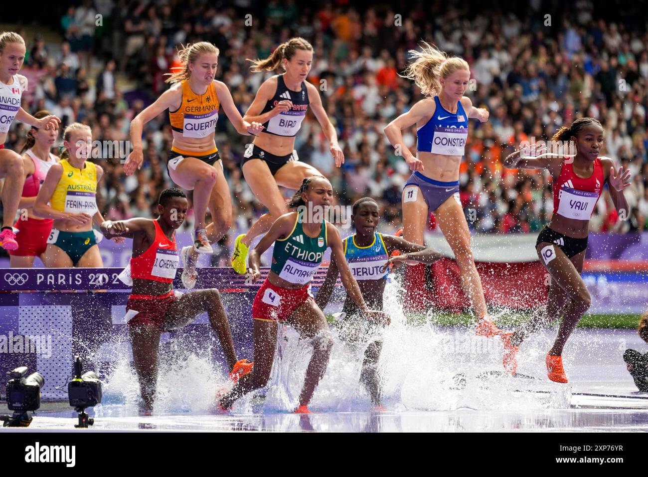 Competitors jump into the water during the women's 3000 meter ...