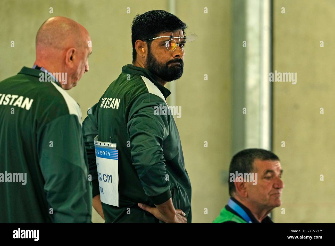 A referee checks the empty cartridges of Pakistan's Ghulam Mustafa ...