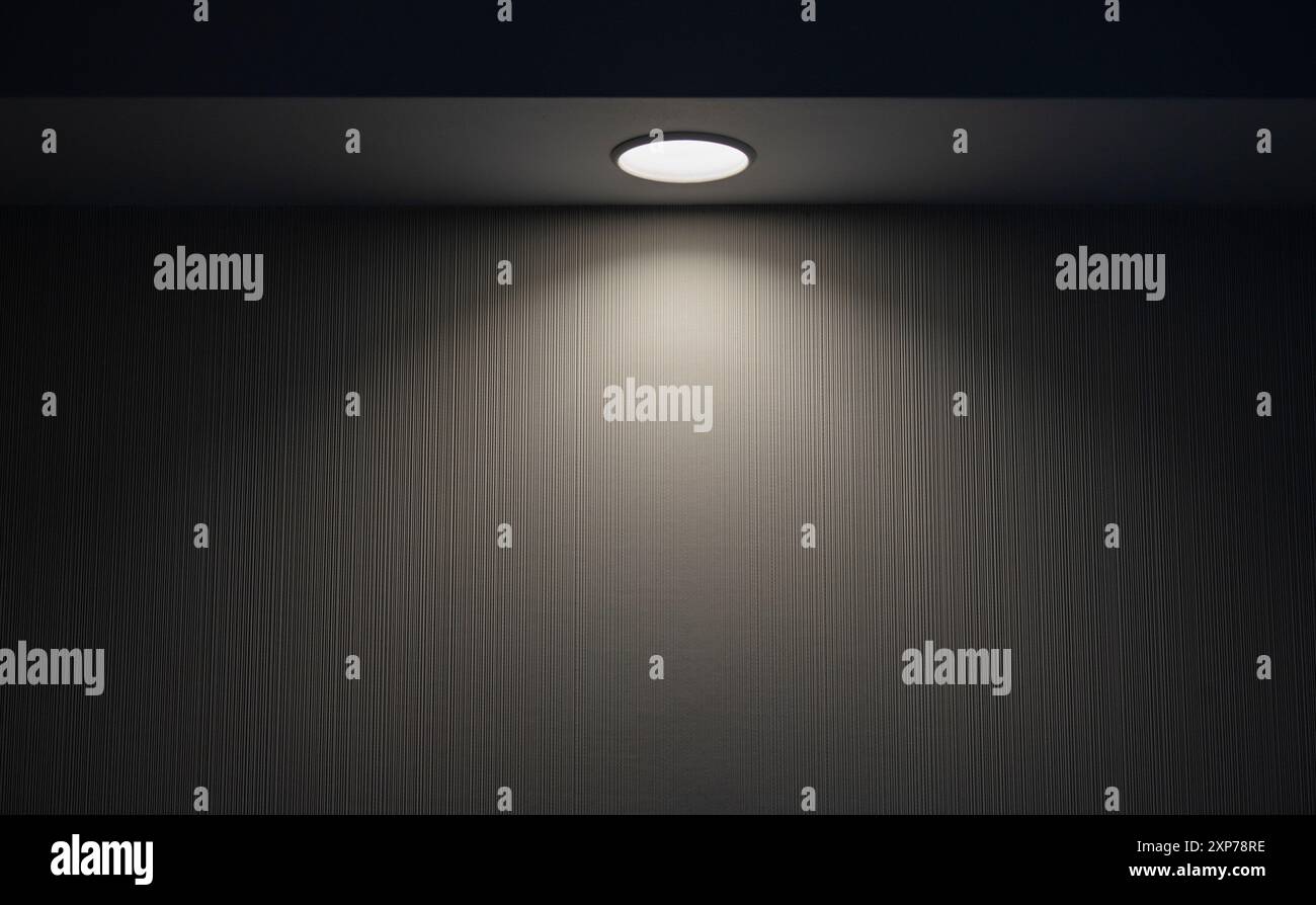 Ray of light from round compact lamp in dark room during night time ...