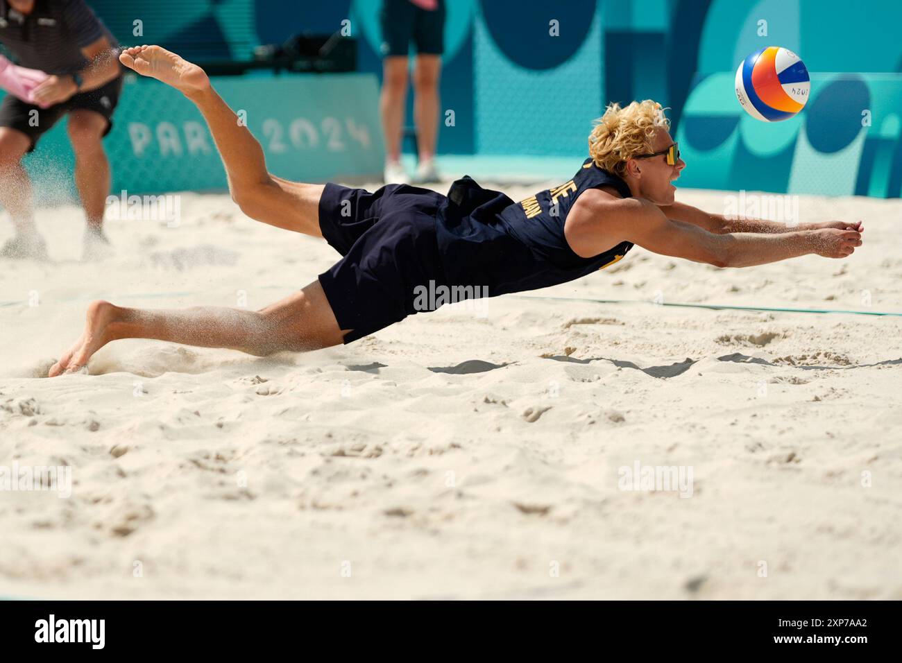 Sweden's David Ahmad dives fe the ball in a beach volleyball match ...