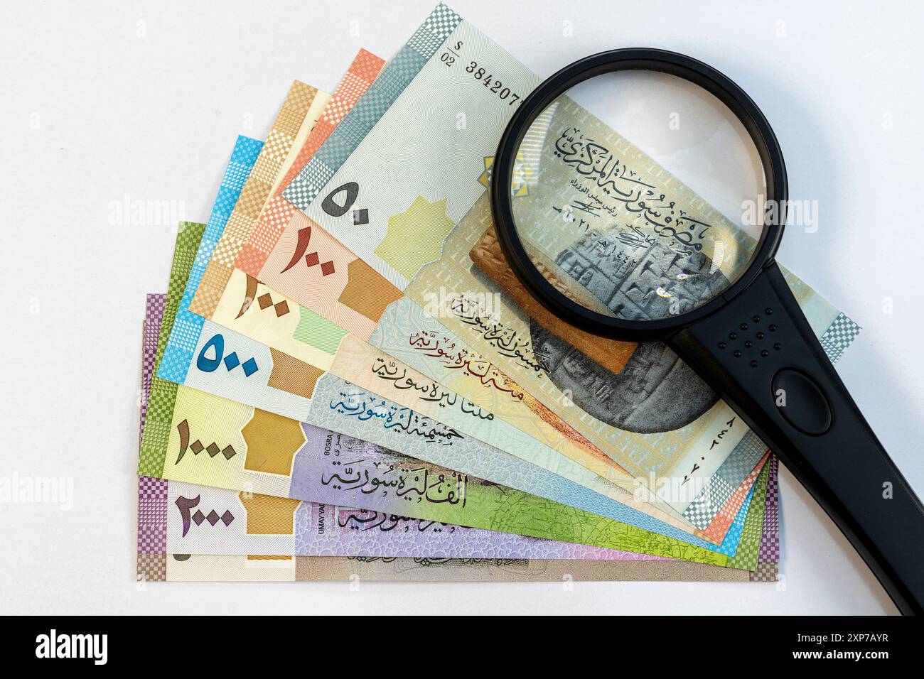 Syria currency banknotes with magnifying glass isolated on white ...