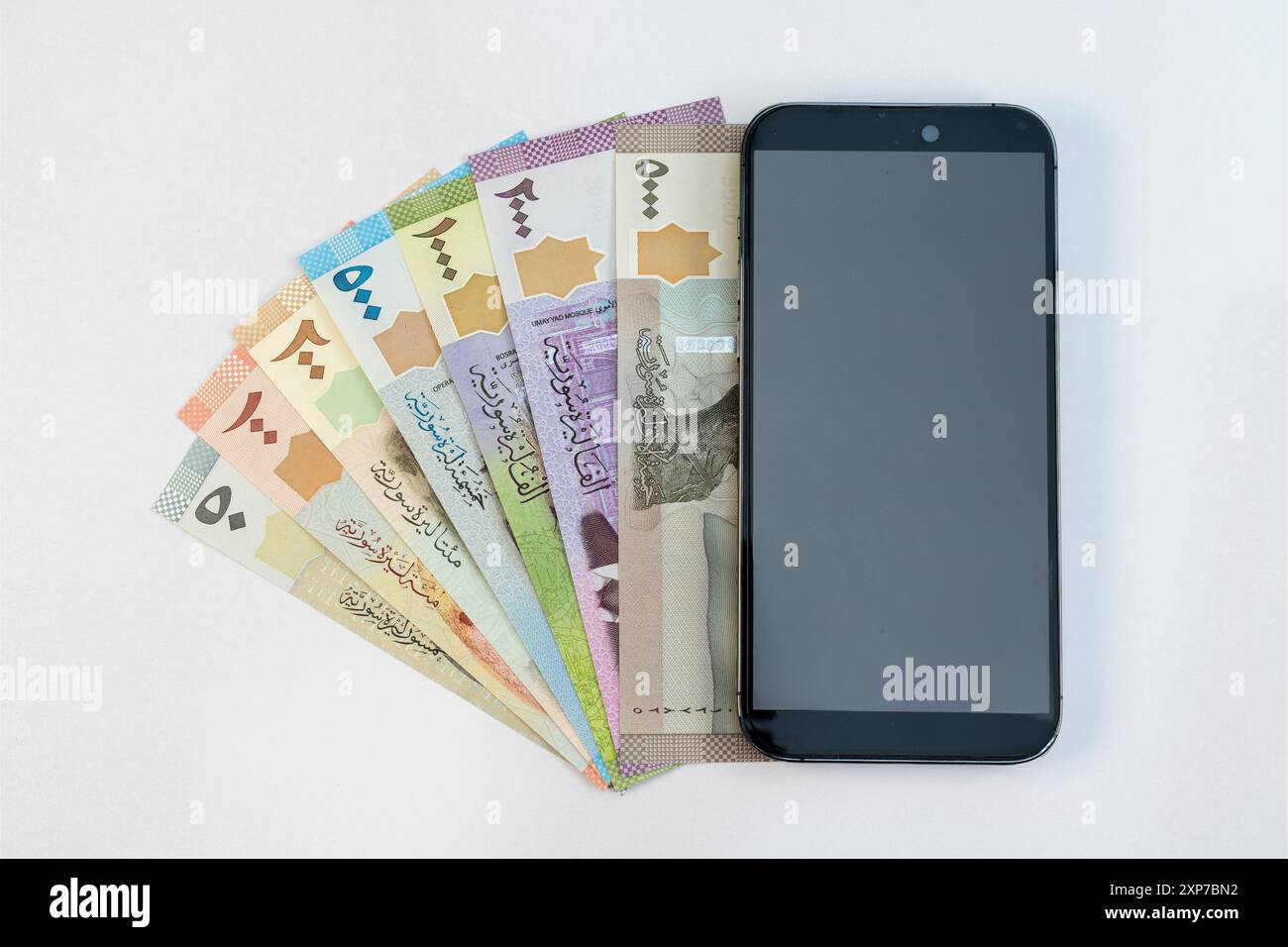 Syria banknotes with smart phone isolated on white background Stock ...