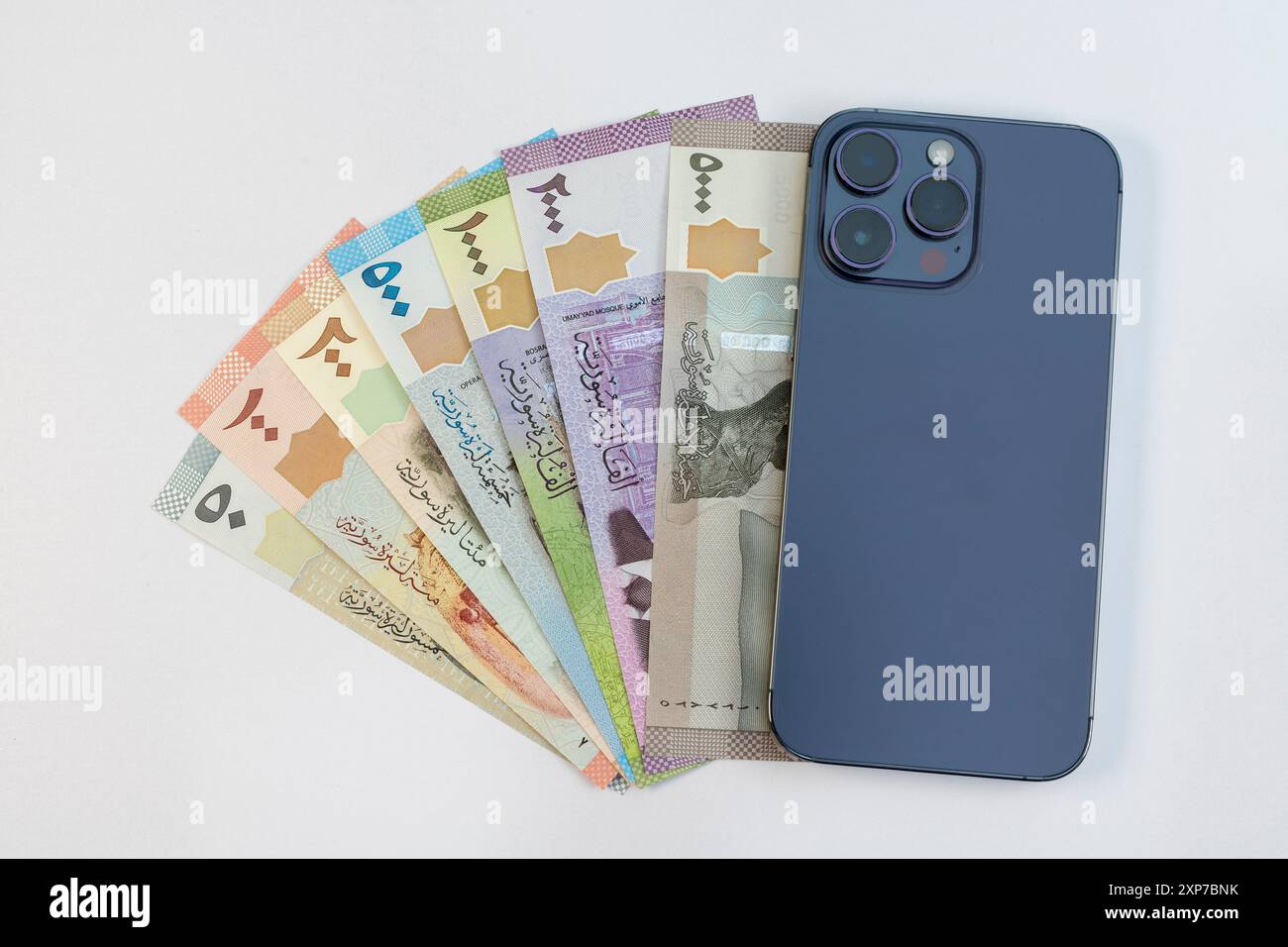 Syrian currency notes with smartphone on white background. Mobile ...