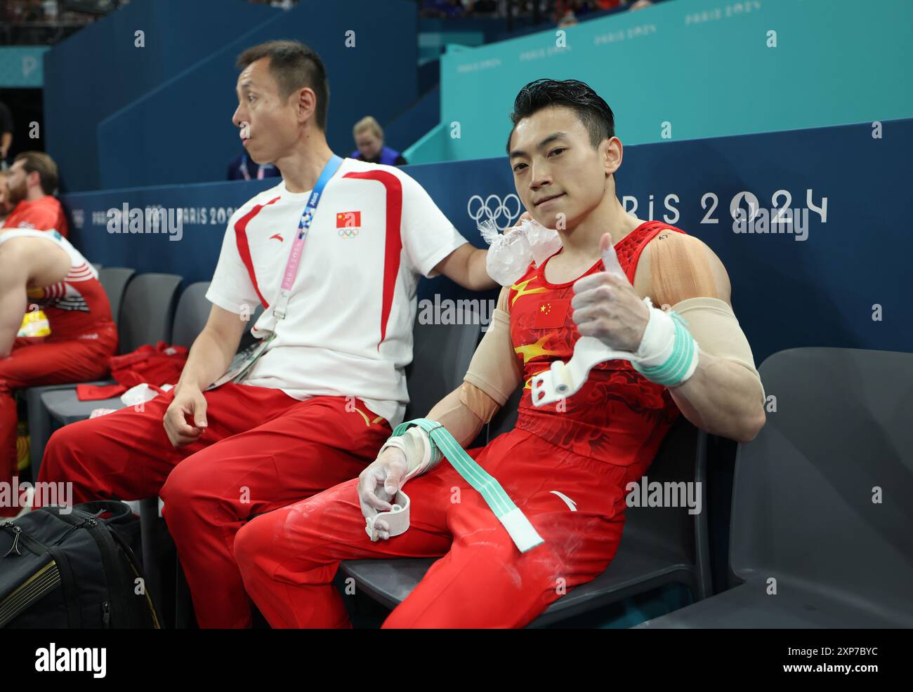 Paris, France. 4th Aug, 2024. Zou Jingyuan (L) of China reacts during the men's rings final of ...