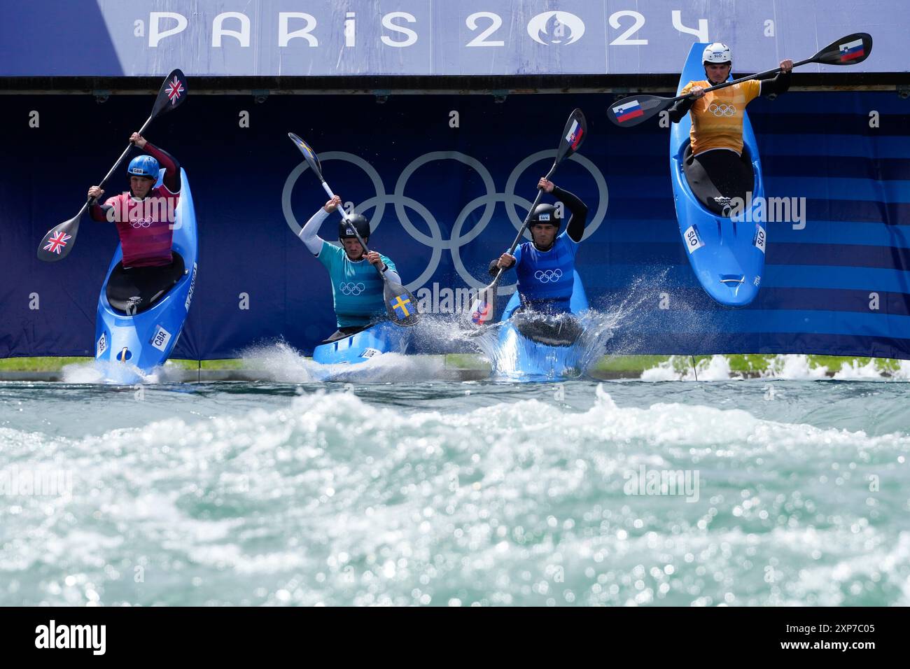 Joseph Clarke of Britain, from left, competes in the men's kayak cross ...