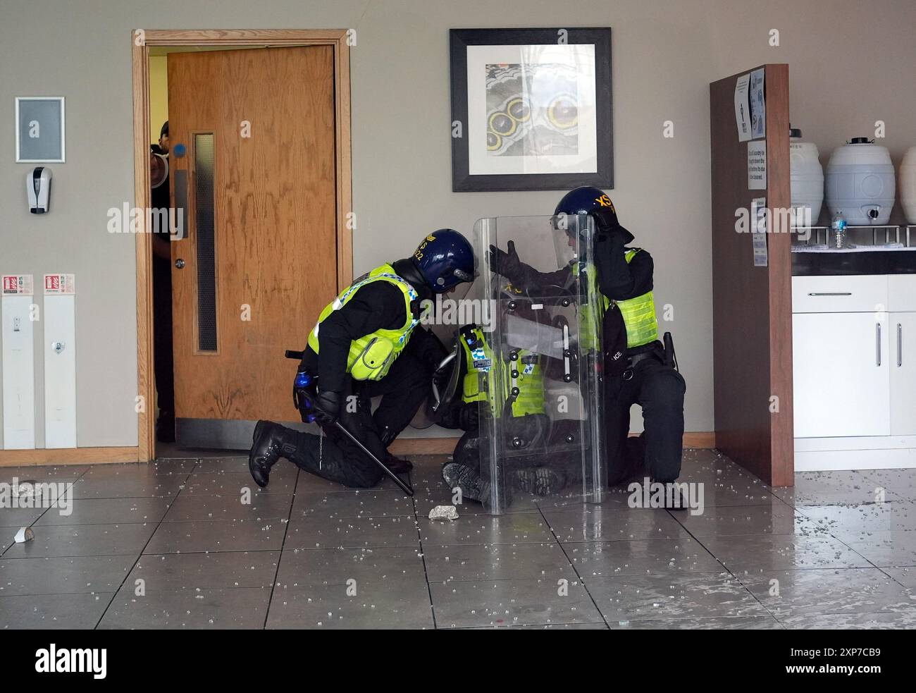 Police officers tend to a wounded colleague inside the hotel as seen ...