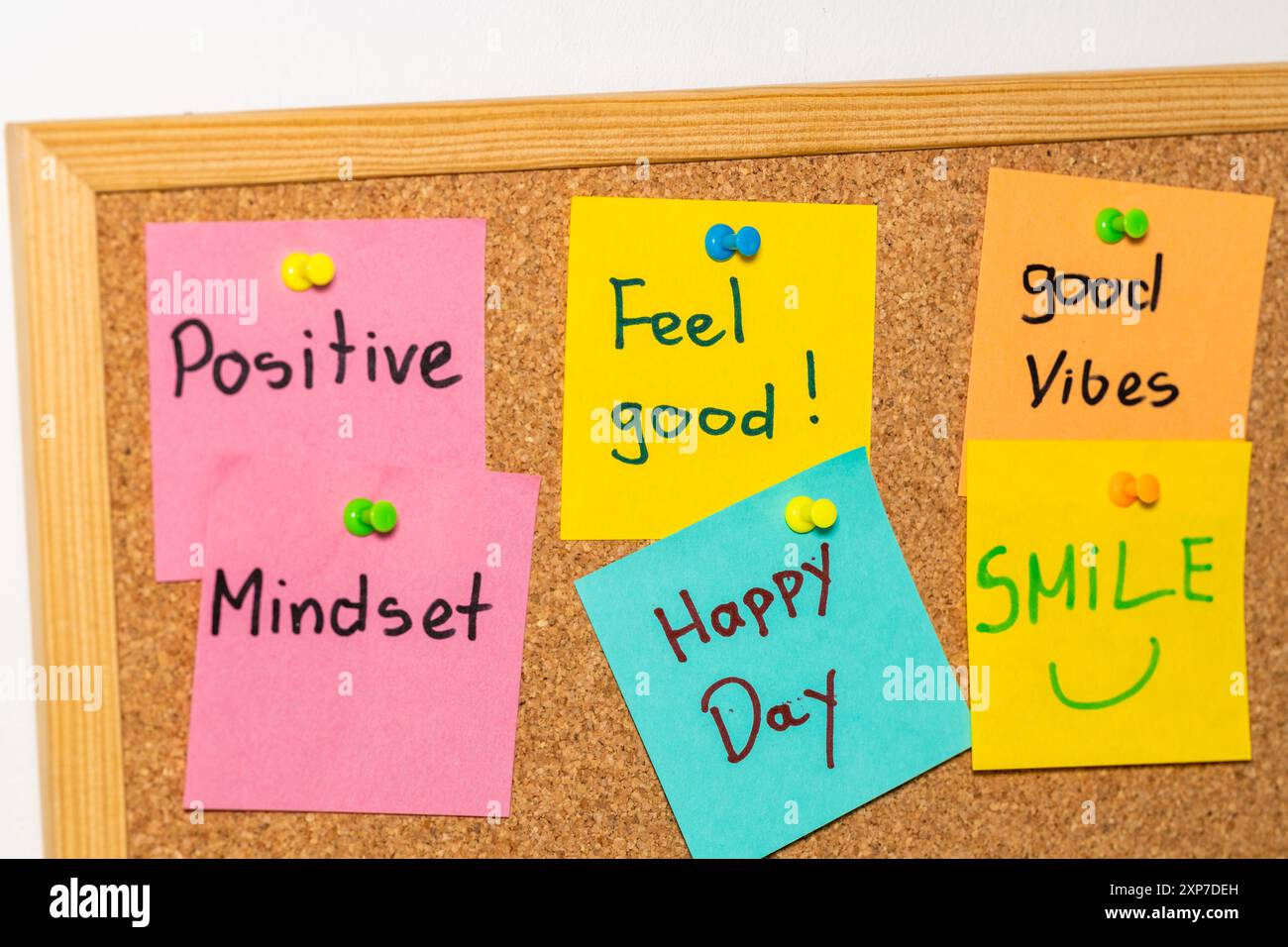 A colorful set of positive thinking sticky notes attached to a board ...