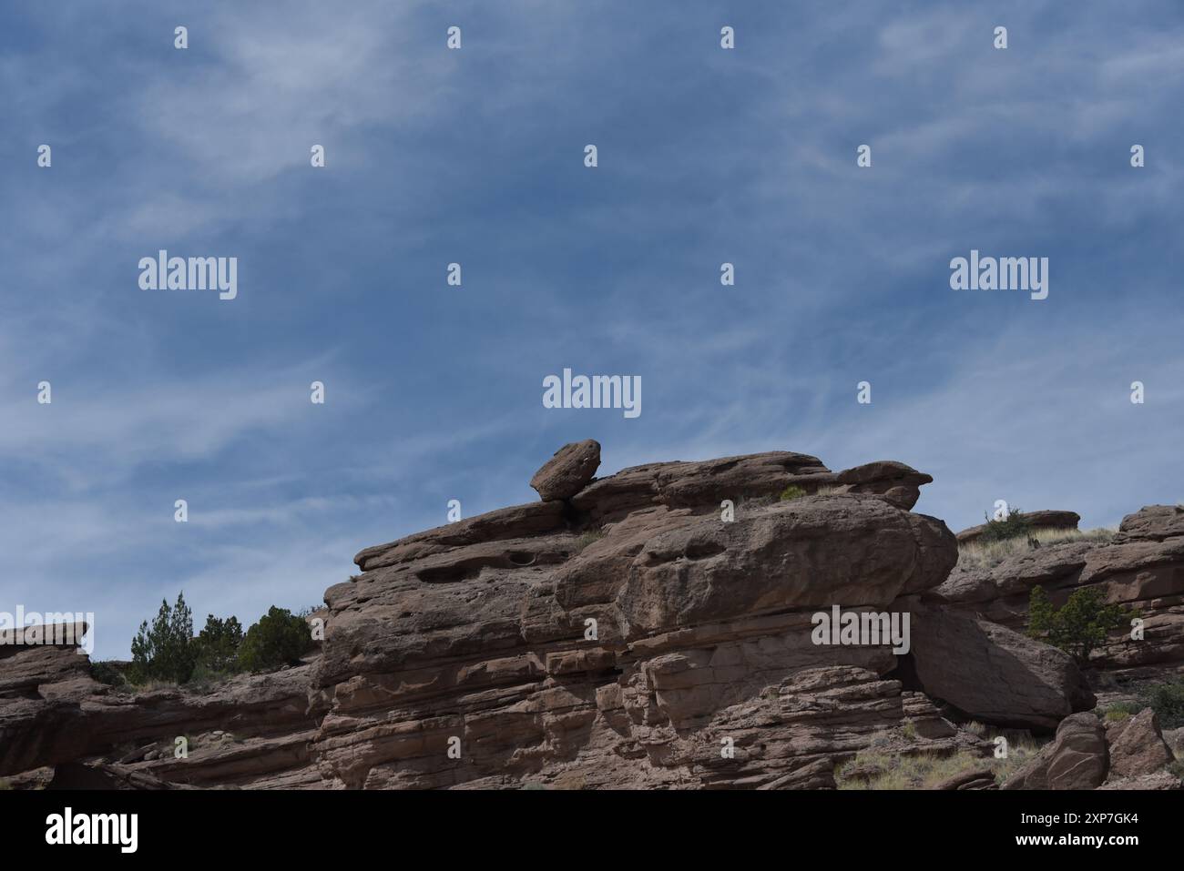 Boulder balances on the top of a sandstone cliff in San Lorenzo Canyon ...