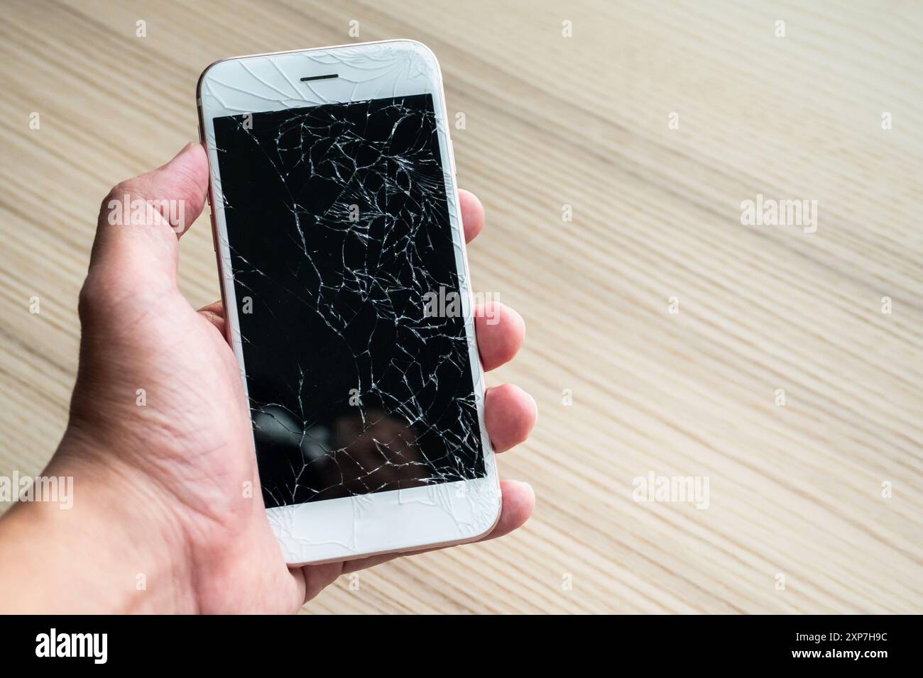 Hand holding mobile phone with broken glass screen Stock Photo - Alamy