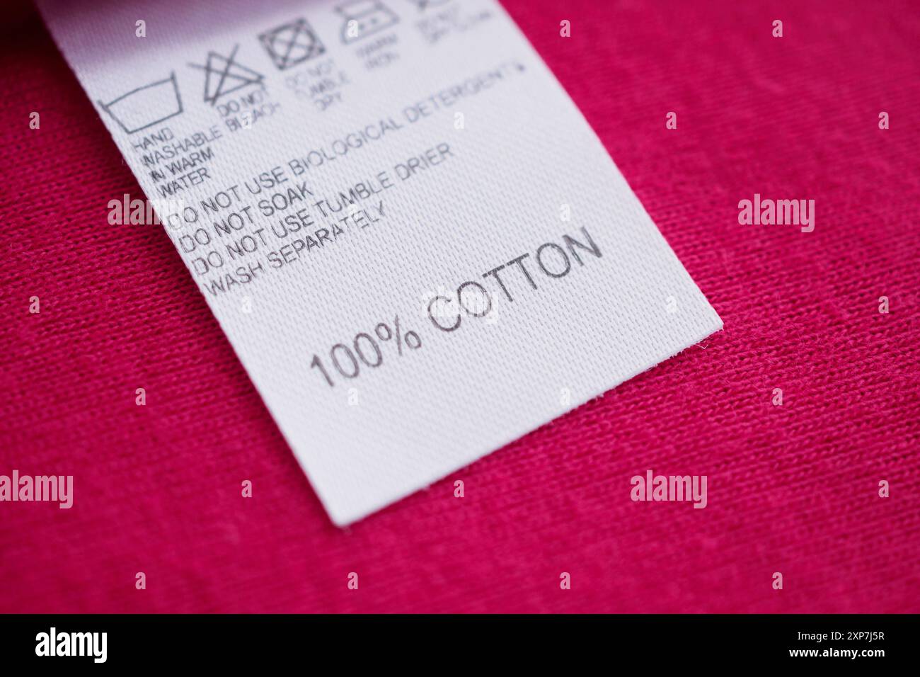 White laundry care washing instructions clothes label on red cotton ...