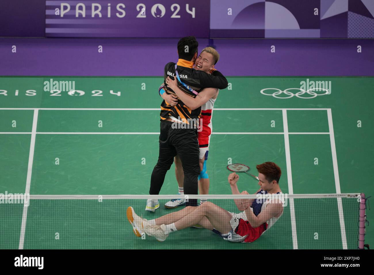 Malaysia's Aaron Chia and Soh Wooi Yik celebrate with their coach after defeating Denmark's Kim ...