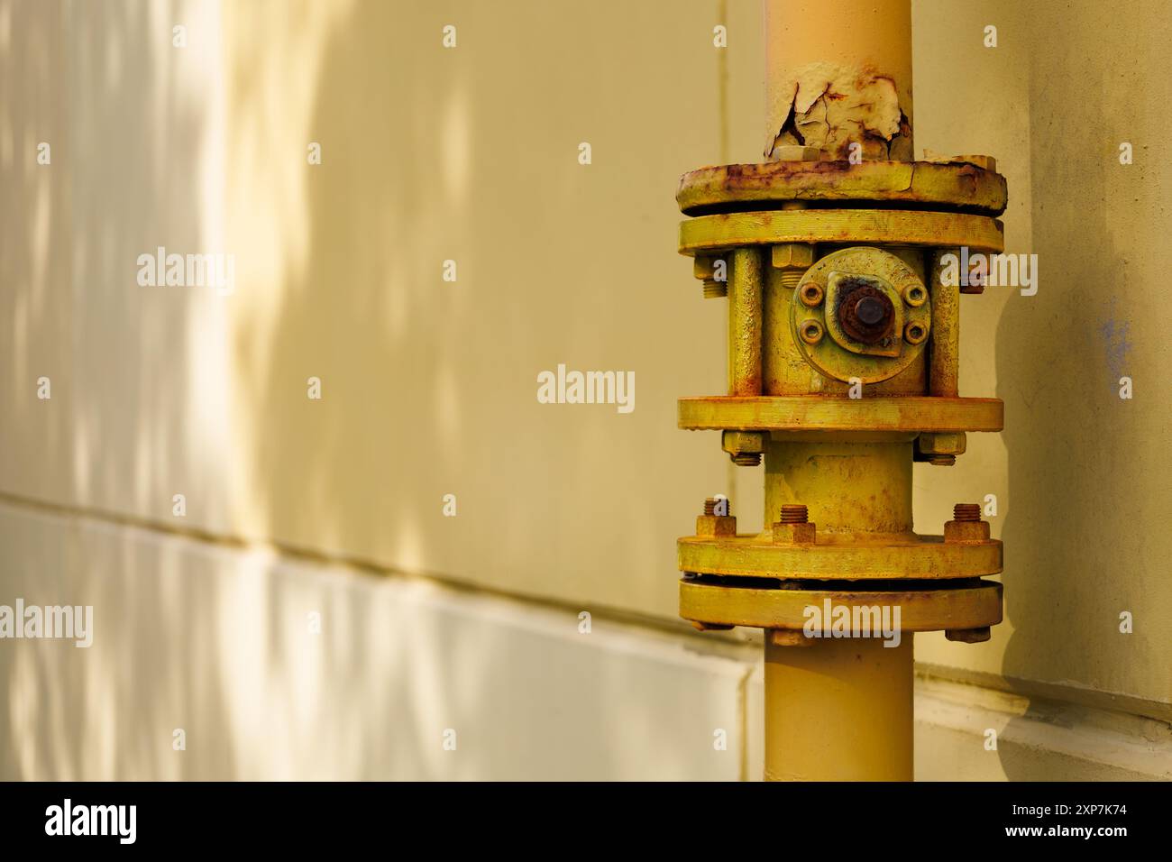 Yellow ground gas pipe on the building. Big grunge control valve. Gas ...