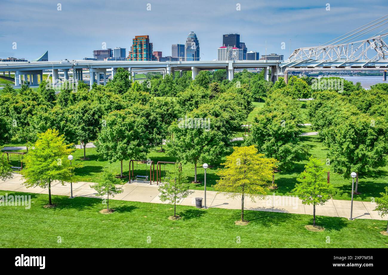 A tree-filled section of Waterfront Park, a linear park in Louisville ...