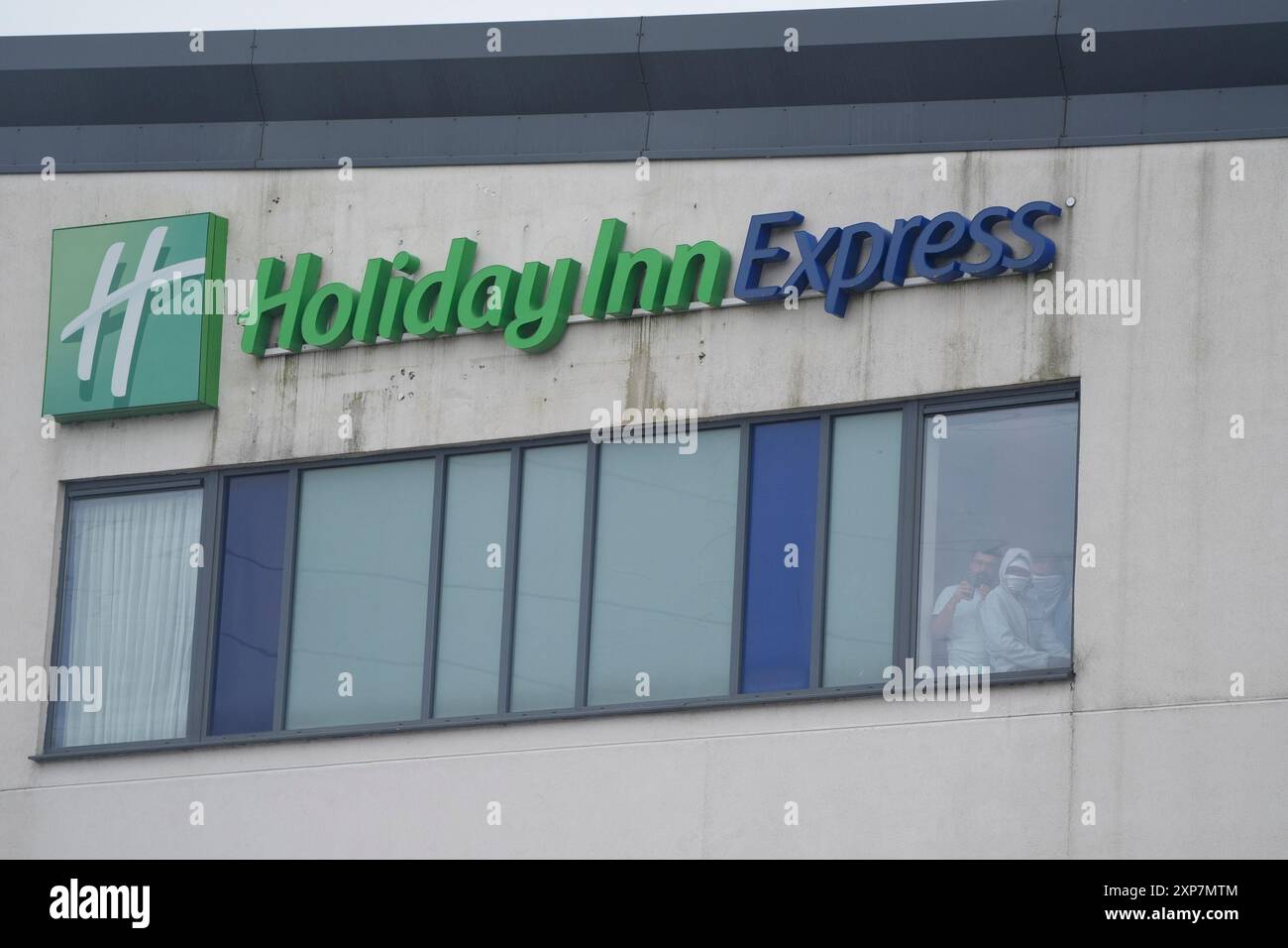 People watch from a window inside the Holiday Inn Express in Rotherham ...