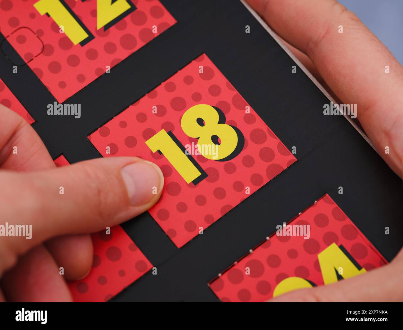 A woman hand ready to open the door with number 18 on the advent ...