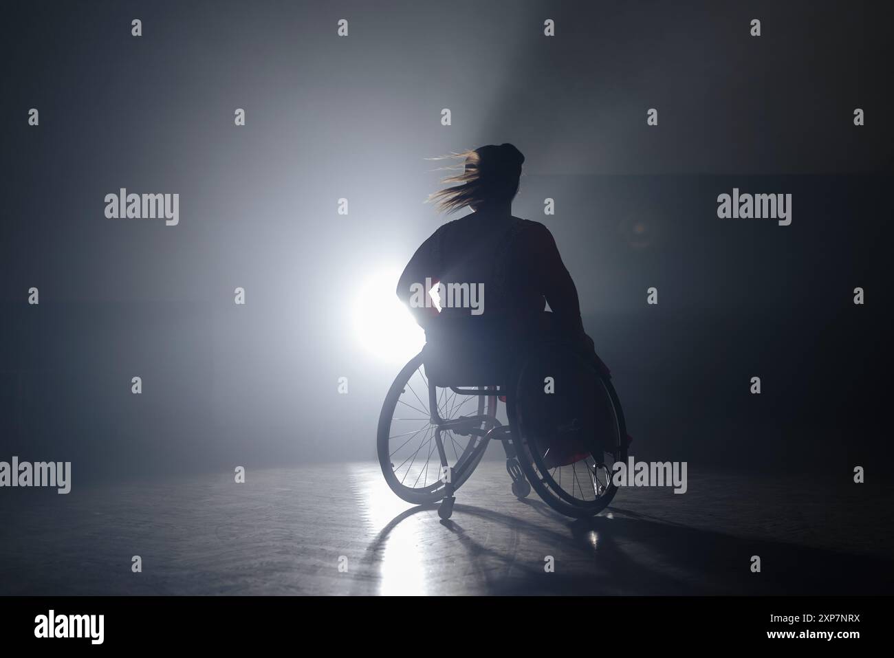 Woman performing graceful dance movements whirling on a wheelchair ...