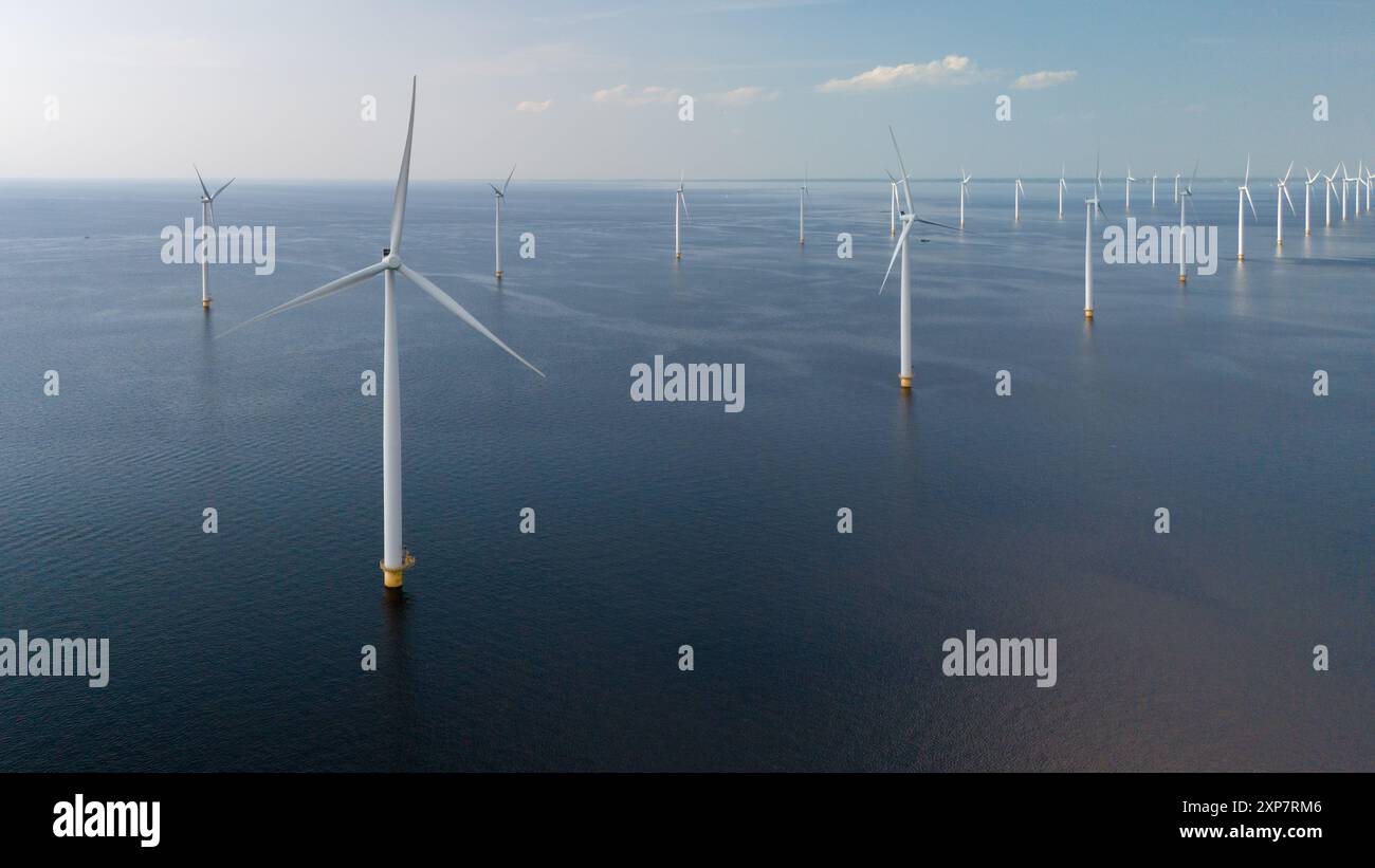 Towering windmills gracefully spin above the calm waters of the North ...