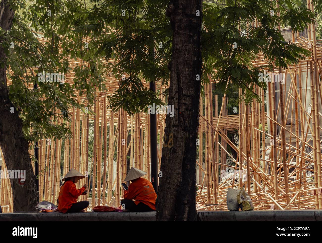 Construction workers sitting on break in front of bamboo scaffolding in ...