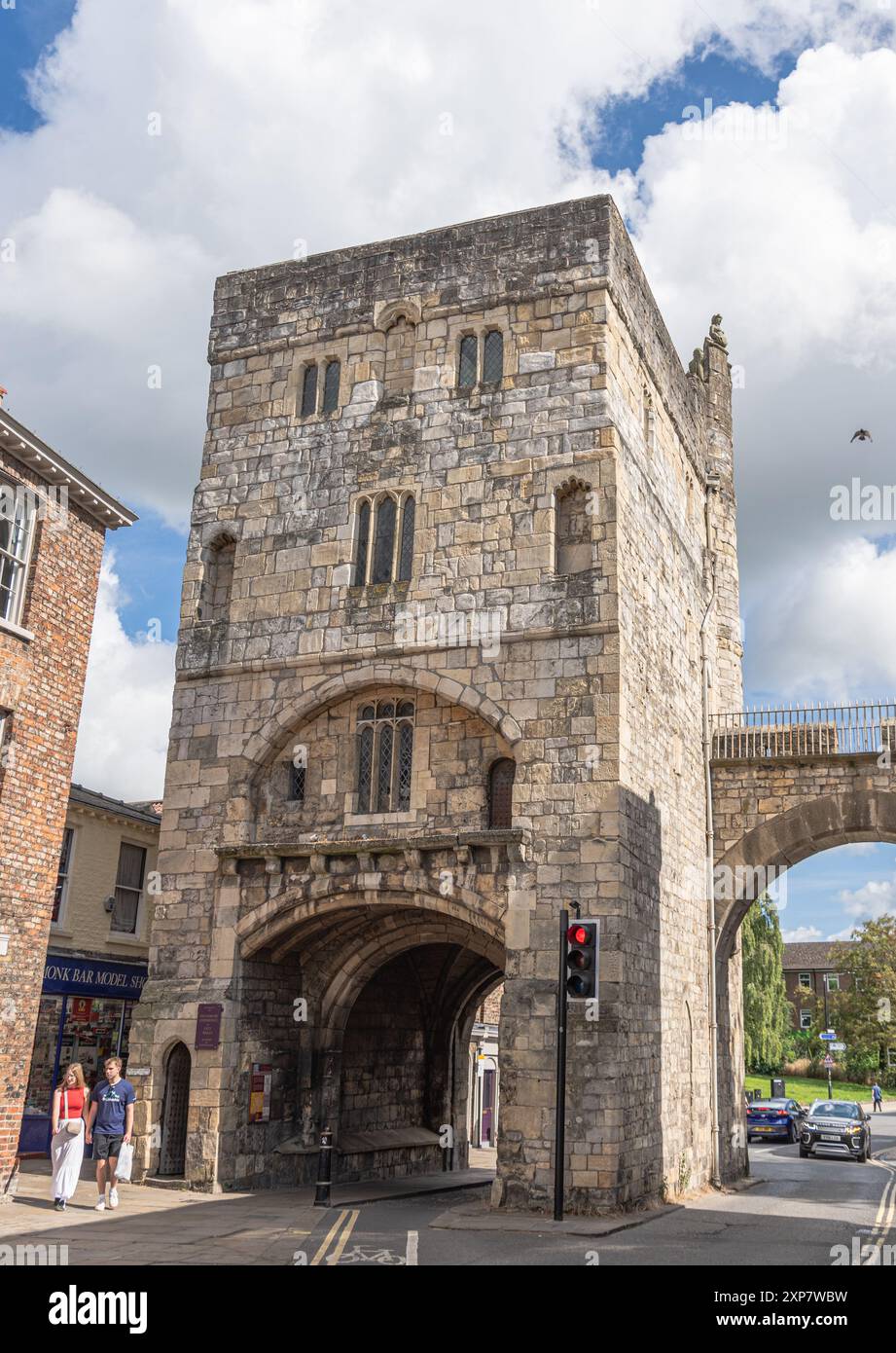 Historic city gateway with an arch and a city wall in the sunshine. A ...