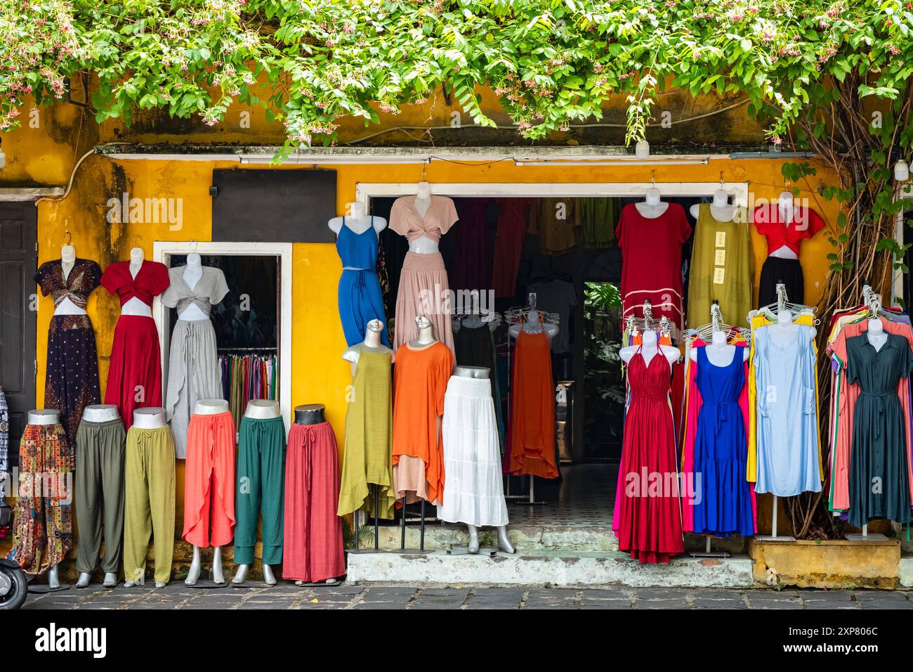 Colorful summer clothes on for sale in shop. Assortment in a clothing ...