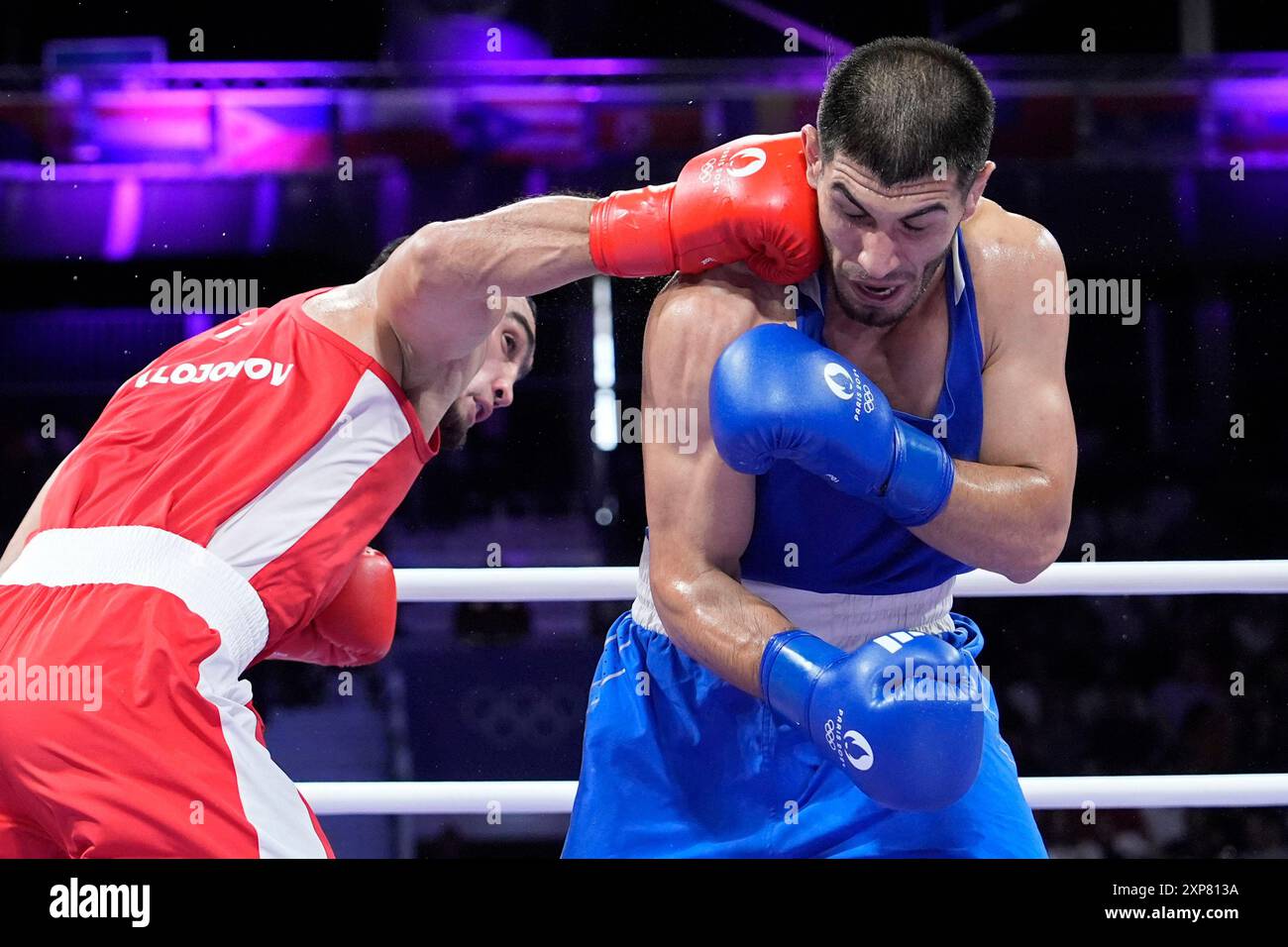 Uzbekistan's Lazizbek Mullojonov hits Tajikistan's Davlat Boltaev in their men's 92 kg semifinal ...